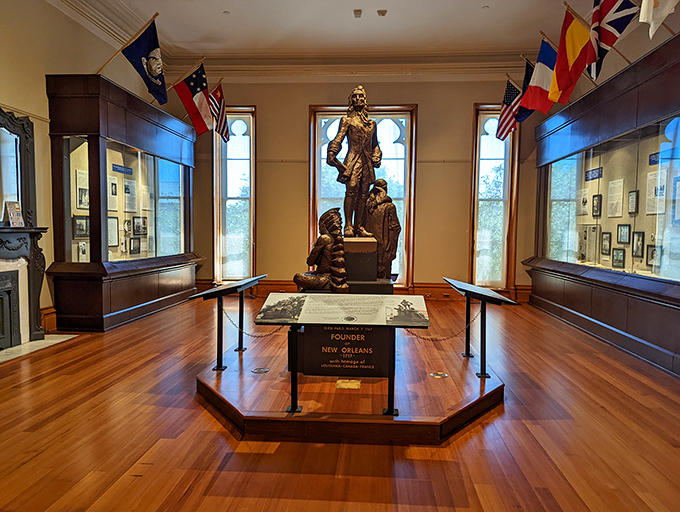 This bronze statue commemorates New Orleans' founders, standing watch in a room bathed in light from Gothic-arched windows.