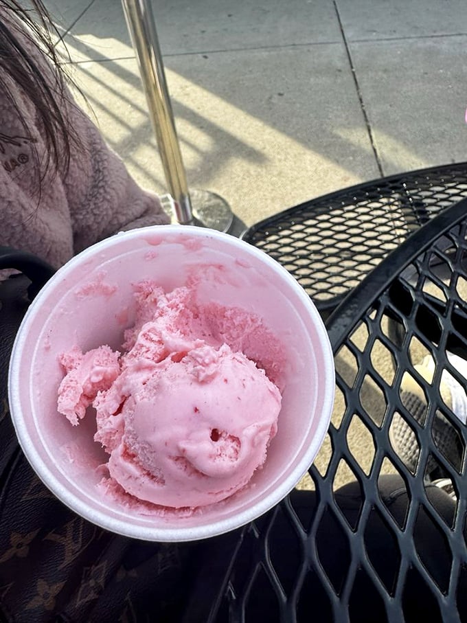 Strawberry ice cream in its natural habitat&mdash;a metal patio table on a sunny day. This vibrant pink scoop is summer distilled into its most essential form.