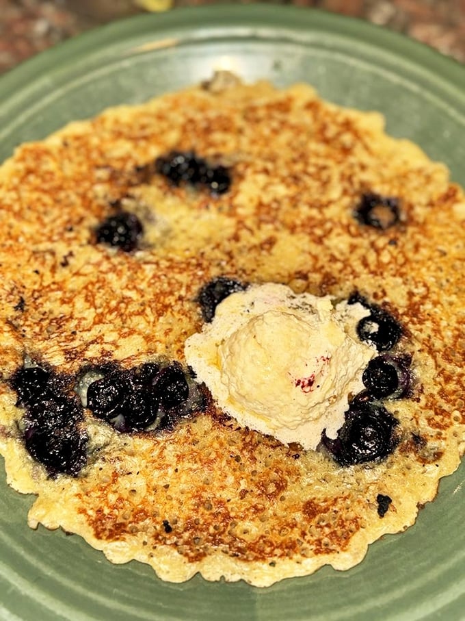 This blueberry pancake isn't just breakfast&mdash;it's edible art with berries playing hide and seek beneath a golden crust and melting butter crown.