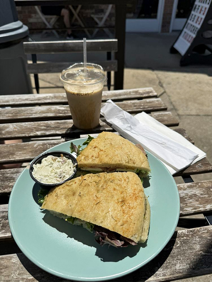 Rustic elegance on weathered wood: a focaccia sandwich that delivers substance and style, paired with a coffee sidekick.