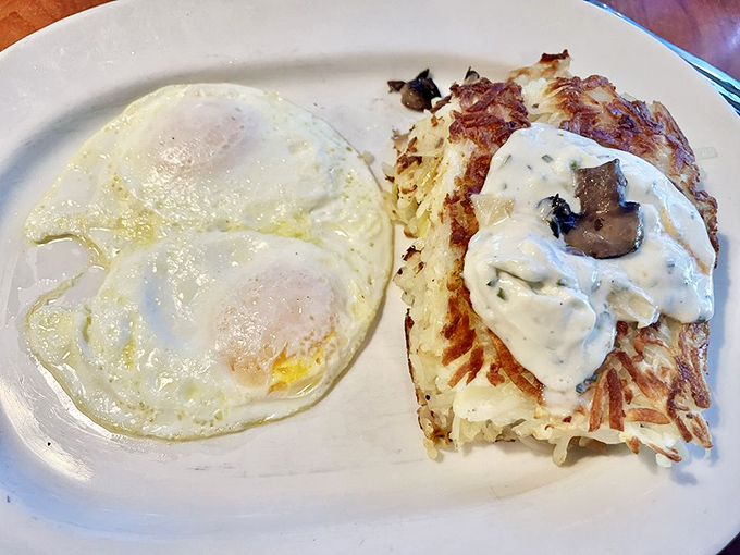 The perfect sunny-side up egg alongside hash browns with mushroom cream sauce—proof that breakfast is the most important art form of the day.