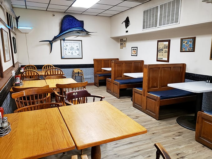 That mounted swordfish watches over diners like a guardian of good taste. The booth seating says "Stay awhile" in the universal language of comfort.