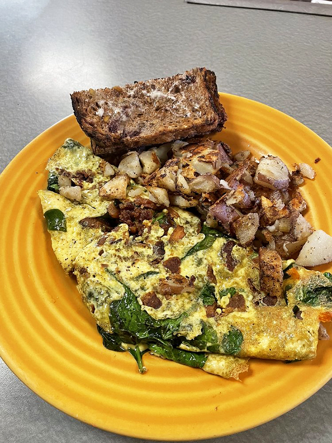Sunshine on a plate – a golden omelet filled with garden-fresh vegetables alongside perfectly crisped potatoes. That multigrain toast is ready for mopping duties.