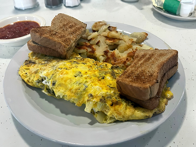 This isn't just an omelet &ndash; it's a fluffy yellow canvas painted with fillings, accompanied by toast standing at attention and hash browns crisped to golden perfection.