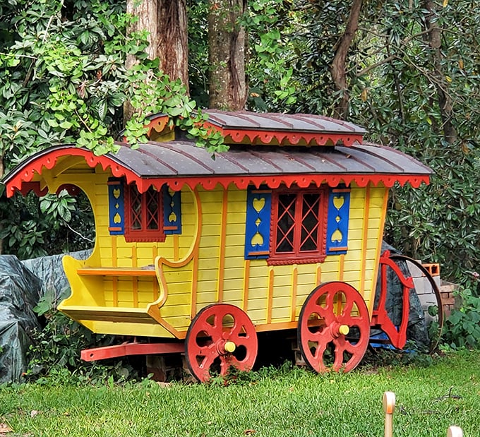 This isn't just any wagon&mdash;it's a gypsy caravan of dreams! The vibrant yellow exterior and red wheels pop against the green landscape.
