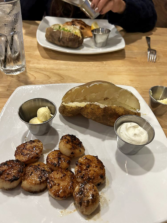 These delicately caramelized scallops aren't just seafood – they're little golden discs of ocean sweetness, performing a perfect opening act for the main event.