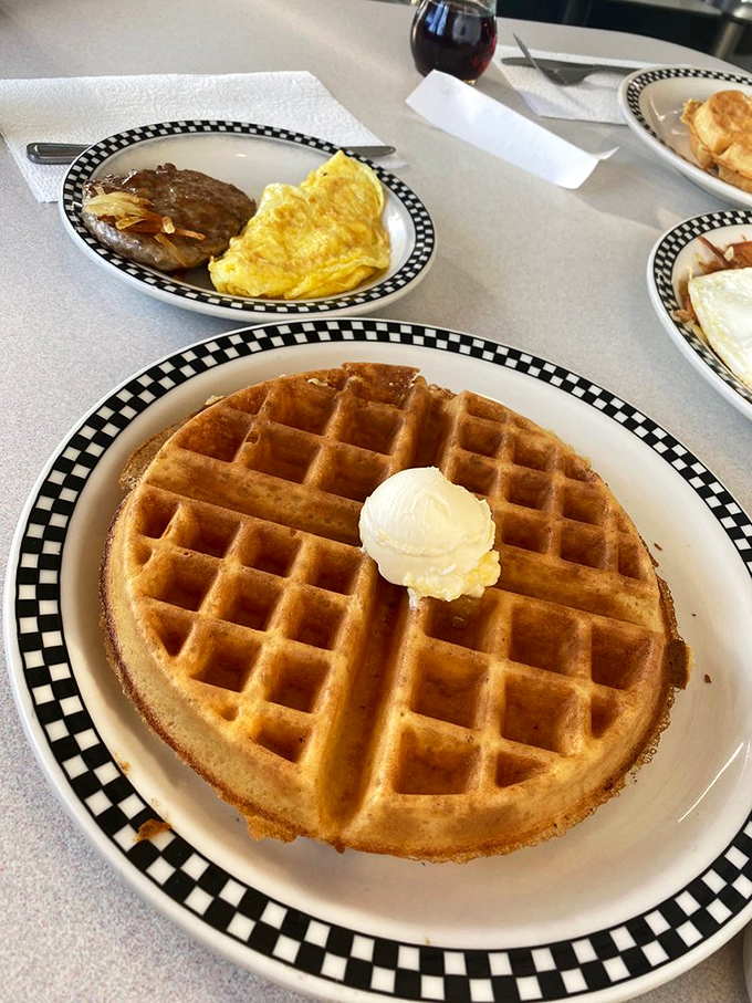 A waffle large enough to have its own ZIP code! That perfect butter crown slowly melting into those golden squares is breakfast theater at its finest.