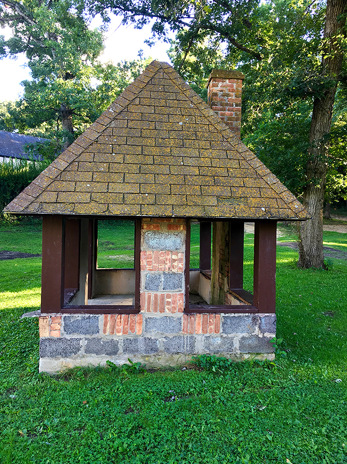 This charming miniature structure looks like where garden gnomes might hold their town meetings. Whimsical architecture on a pint-sized scale.