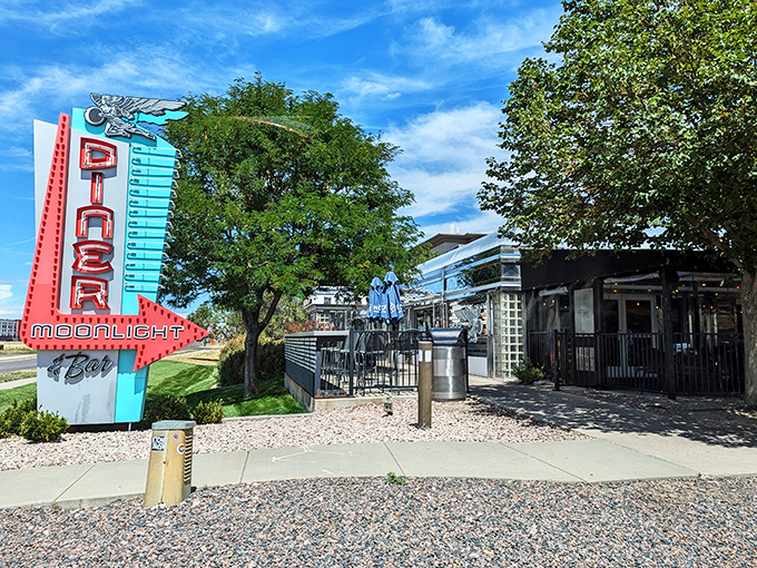 Moonlight Diner's retro sign stands tall against Colorado's sky &ndash; a neon promise of pancakes and nostalgia just minutes from your departure gate.