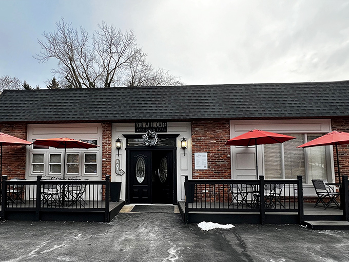 The unassuming brick exterior of Old Mill Cafe beckons with its elegant black doors and cheerful red umbrellas—like a secret breakfast society waiting to initiate you.