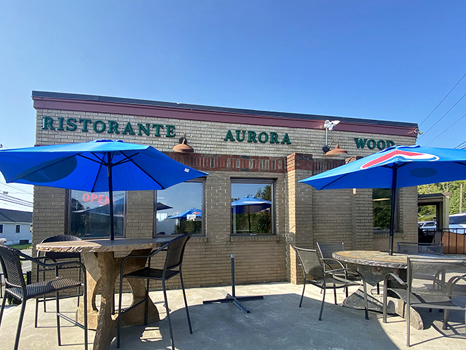 The classic roadside charm of Aurora Diner beckons hungry travelers with its promise of comfort food and that unmistakable blue-umbrella welcome.