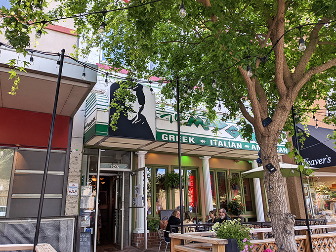 The Mad Greek's inviting storefront beckons with classic white columns and cheerful patio umbrellas&mdash;Massachusetts Street's little slice of Athens awaits your discovery.