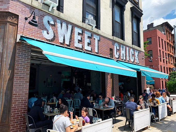 The unmistakable pink brick exterior of Sweet Chick beckons hungry passersby with its warm glow and picnic tables that practically whisper, "Pull up a seat, friend."