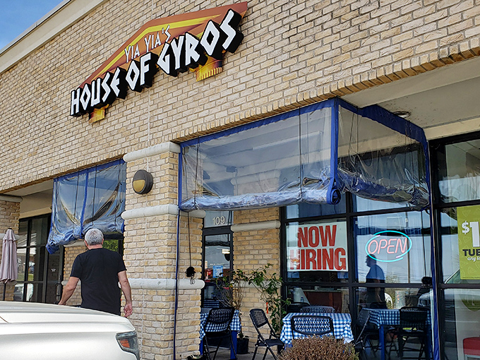 The glowing sign of Yia Yia's House of Gyros beckons like a Mediterranean lighthouse in a sea of Texas strip malls. Greek paradise awaits inside!