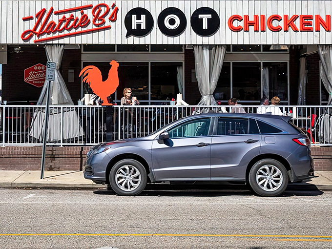 The iconic red rooster stands guard outside Hattie B's, a beacon of spicy salvation for heat-seekers across Alabama.