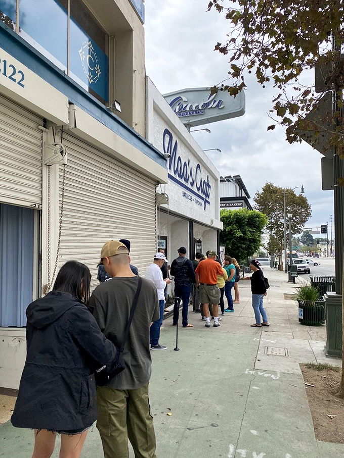 The white storefront with bold blue lettering promises what lies within: meat magic that'll make your cardiologist wince and your taste buds dance.