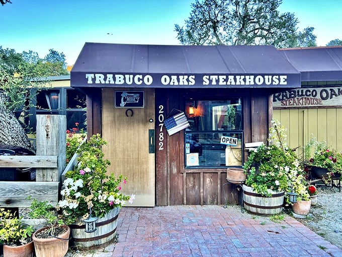 The unassuming wooden exterior of Trabuco Oaks Steakhouse promises rustic charm and serious steak business. Those barrel planters aren't just for show&mdash;they're your first hint of the no-nonsense authenticity waiting inside.