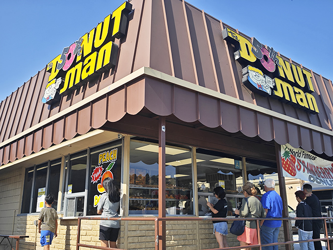 The iconic brown A-frame building stands proudly along Route 66, beckoning donut pilgrims with its cheerful signage and promise of strawberry-filled bliss.