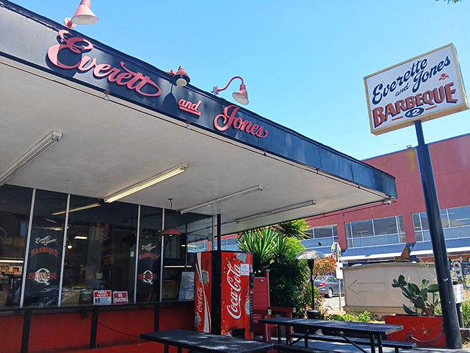 The iconic red and black storefront beckons like a barbecue lighthouse on San Pablo Avenue, promising smoky treasures within.
