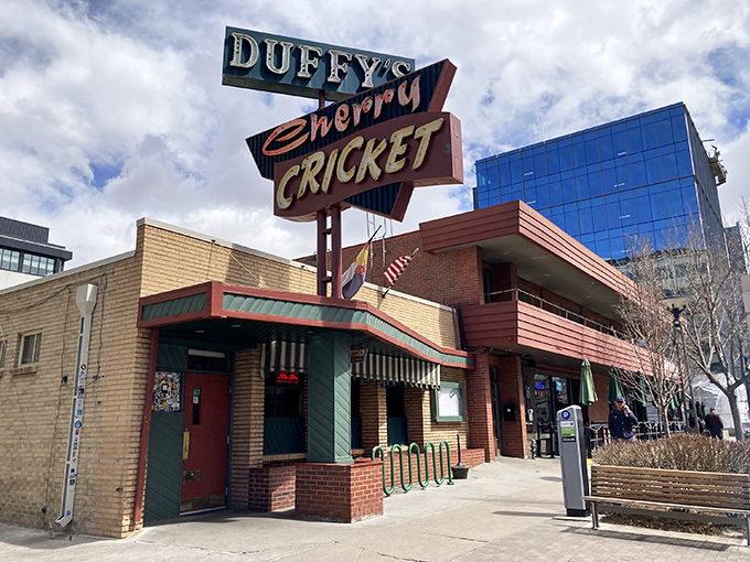 The iconic Duffy's Cherry Cricket sign stands as a beacon of burger bliss in Denver's Cherry Creek neighborhood, promising unpretentious delights within those brick walls.