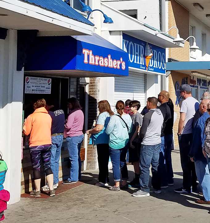 The iconic blue and orange Thrasher's sign beckons beach-goers like a potato-powered lighthouse on Rehoboth's boardwalk. Summer pilgrimage status: mandatory.