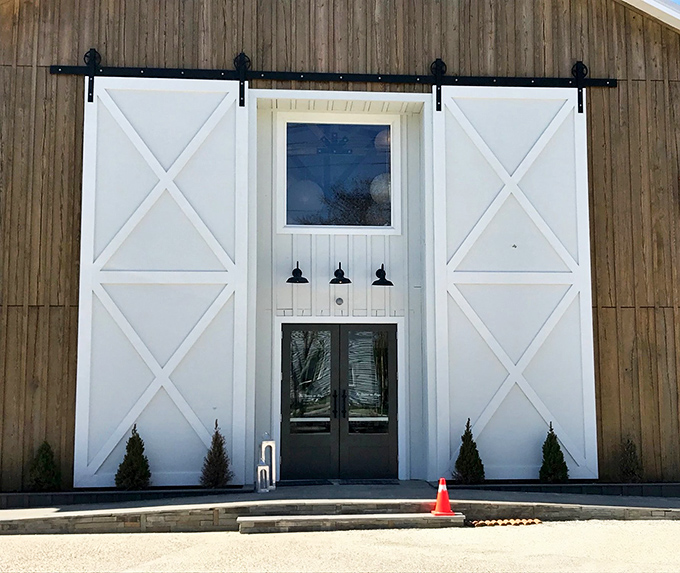 The rustic barn-like exterior of The Station on Kings beckons with its striking white barn doors&mdash;architectural simplicity that promises culinary sophistication inside.