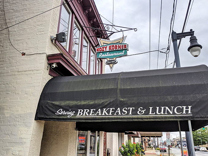 The vintage sign beckons like an old friend, promising comfort food salvation beneath that classic black awning. Breakfast paradise awaits.