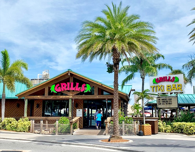 Florida's tropical paradise in architectural form. Palm trees stand guard as Grills' vibrant signage beckons hungry travelers into its wooden embrace.