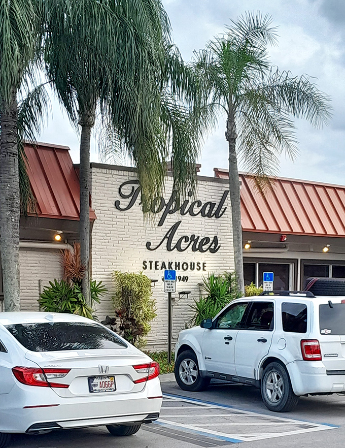 Tropical Acres stands like a time-honored oasis amid swaying palms, its iconic red roof and yellow walls promising culinary treasures within.