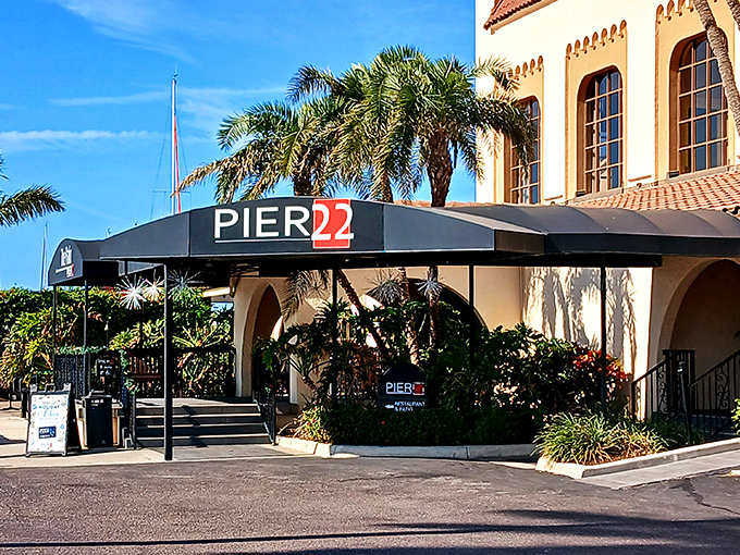 Mediterranean elegance meets Florida sunshine at PIER 22's entrance, where palm trees stand guard and the promise of waterfront dining beckons.