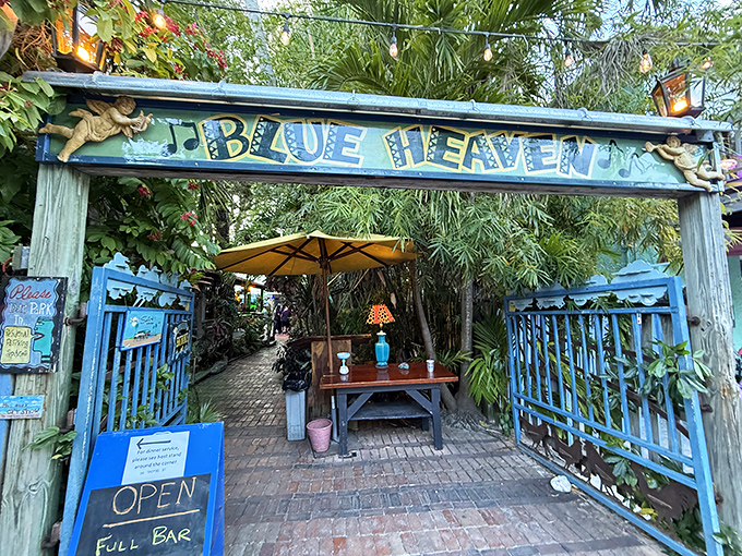 The iconic blue gates of Blue Heaven welcome you like old friends, promising tropical delights and Key West charm beyond the threshold.