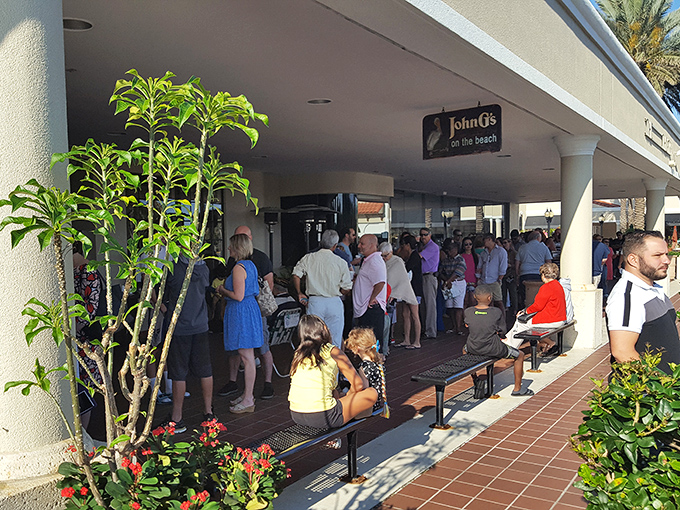 The line forms early at John G's, where patient food pilgrims gather under Florida sunshine. Worth every minute of the wait!