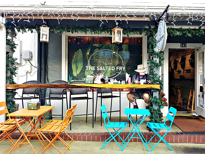 The bright orange outdoor seating at The Salted Fry beckons like a potato-loving friend, promising crispy delights behind that cheerful red door in downtown Mount Dora.