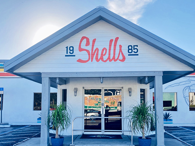 The iconic Shells Seafood storefront welcomes hungry visitors with its distinctive coral-red script and coastal charm. Florida dining at its unpretentious best.