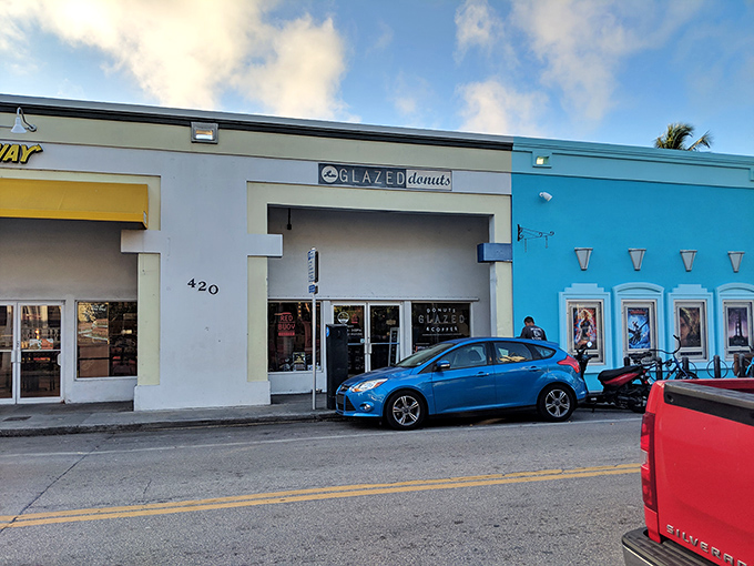 The iconic black and white Glazed Donuts sign beckons sweetly against Key West's blue sky, promising delicious treasures within.