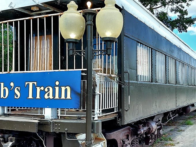 The vintage Pullman car "Jomar" stands proudly in Sarasota, its sleek dark exterior and open flag inviting curious diners to step back in time.