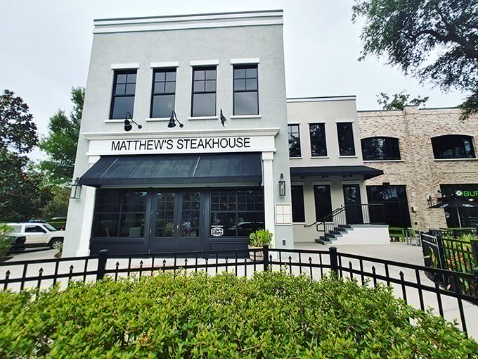 The elegant white façade of Matthew's Steakhouse stands like a culinary beacon in Winter Garden's historic district, promising memorable meals behind those stylish black-framed doors.