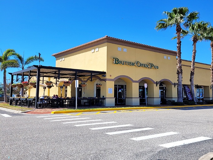 A slice of Britain basks in Florida sunshine. The British Open Pub's cheerful yellow exterior and teal signage create an inviting cultural crossroads where palm trees meet pub tradition.