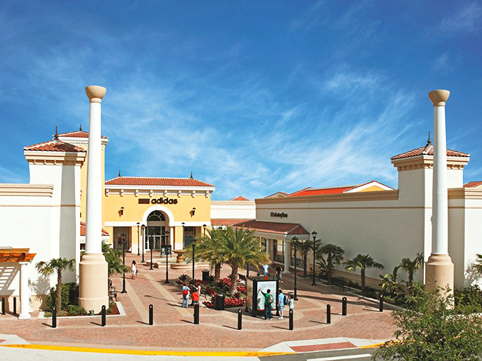 Mediterranean charm meets retail therapy under Florida skies, where shoppers gather like pilgrims at a temple of discounts