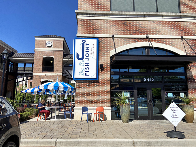 The brick fa&ccedil;ade of Big B's Fish Joint welcomes seafood lovers with its distinctive blue and white signage and inviting patio umbrellas.