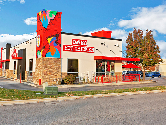 Dave's Hot Chicken's vibrant exterior is like a beacon for spice-seekers, with its bold red signage and eye-catching murals promising a flavor adventure inside.