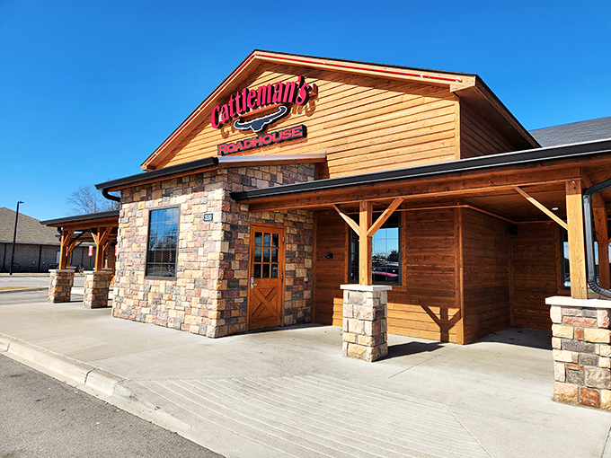 The rustic wood-and-stone exterior of Cattleman's Roadhouse stands like a beacon of hope for hungry travelers. Comfort food paradise awaits inside those doors.