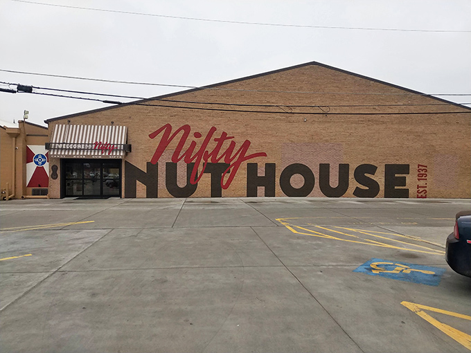 The brick facade of Nifty Nut House beckons like a siren song to sugar enthusiasts. That red script logo promises sweet adventures within.