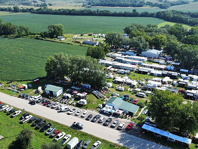 An aerial view reveals Sparks Flea Market's true scale&mdash;a sprawling treasure hunter's paradise nestled among Kansas farmland, where parking lots fill with hopeful bargain seekers.