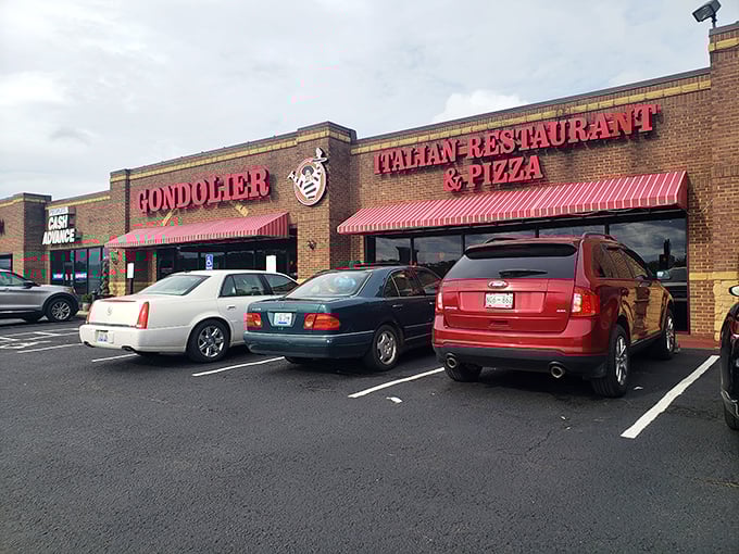 The bold red Gondolier sign beckons like a lighthouse for pasta pilgrims, promising Italian comfort under those distinctive striped awnings.