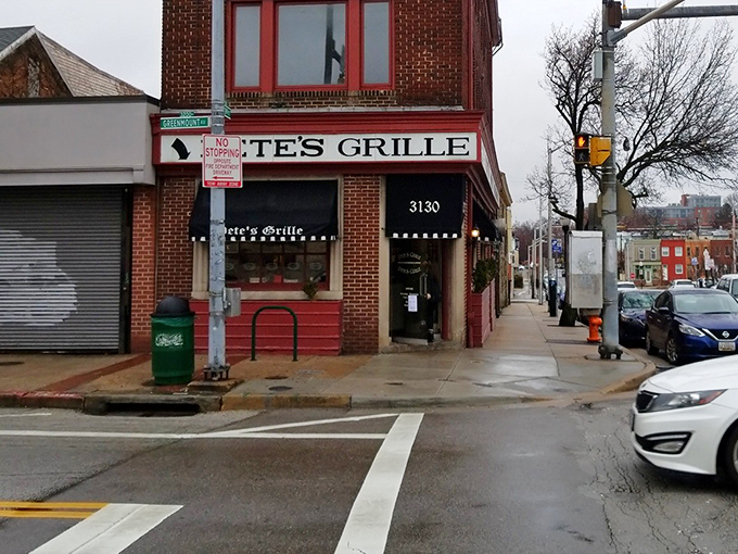 The iconic red brick corner that houses Pete's Grille stands like a beacon of breakfast hope on Greenmount Avenue, promising pancake perfection inside.