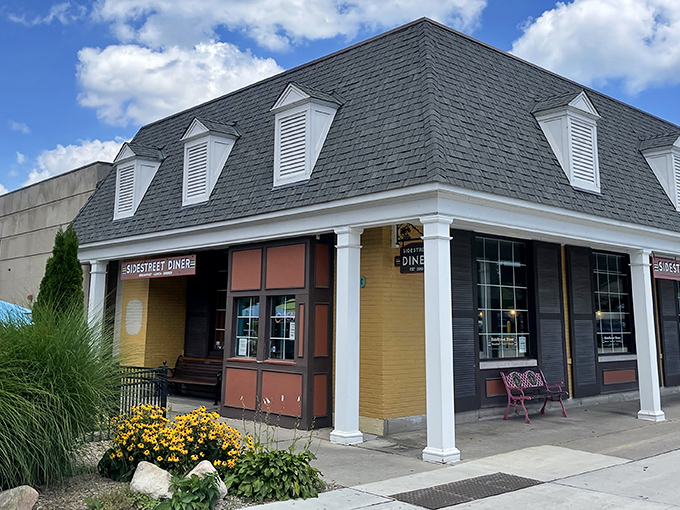 The charming yellow brick exterior of Side Street Diner beckons with its distinctive mansard roof and welcoming entrance. A hidden gem worth seeking out!