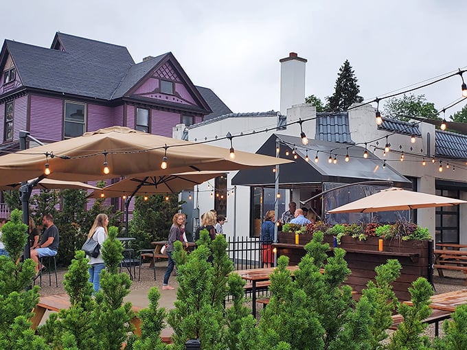 The patio paradise at Donkey Taqueria sits beneath string lights, with the iconic purple Victorian house creating a perfect backdrop for your taco-fueled evening.
