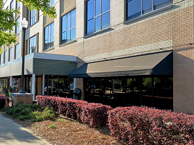 The Manship's elegant brick exterior with vibrant red hedges offers a hint of the culinary magic happening inside this Jackson gem.