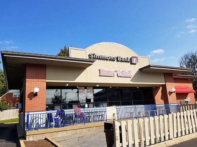 The unassuming brick storefront houses frozen custard magic. Those red umbrellas aren't just for show&mdash;they're beacons calling dessert enthusiasts to paradise.